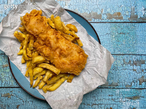Close-up image of takeaway fish and chips with salt and vinegar ...