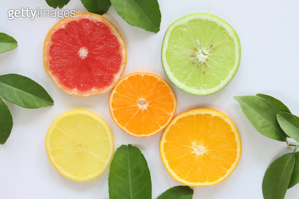 Close-up image of five citrus fruit slices with leaves, cross sections ...
