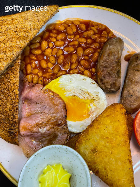 Close-up image of full English fried breakfast of bacon rasher, grilled ...