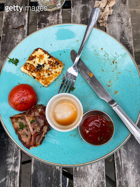 Image of full English breakfast remains on dirty turquoise plate ...