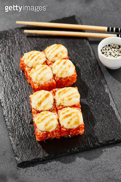 Baked Maki sushi on dark slate. Hot california maki with cheese. Sushi ...