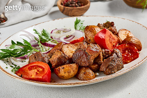 Traditional georgian dish odjahuri with meat and potatoes. Roasted pork ...