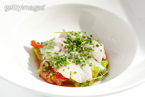 Healthy dinner - fish fillet with tomato and avocado on white plate ...