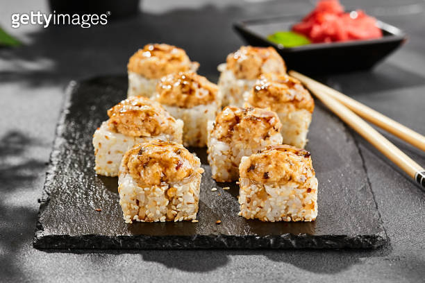 Baked Maki sushi on dark slate. Hot unagi maki with eel. Sushi roll ...