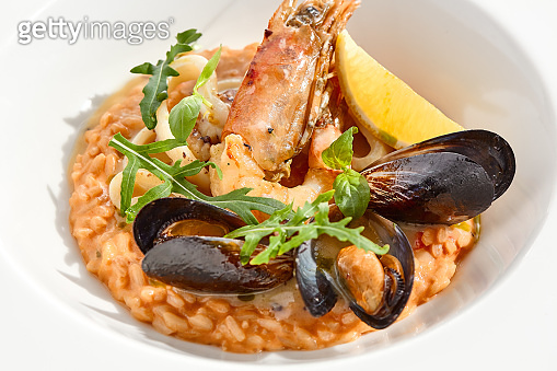 Italian dish - seafood risotto on white plate. Risotto frutti di mare ...