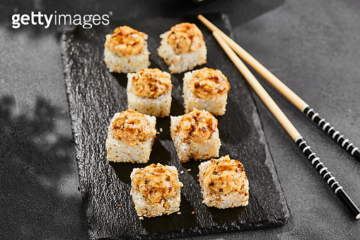 Baked Maki sushi on dark slate. Hot unagi maki with eel. Sushi roll ...