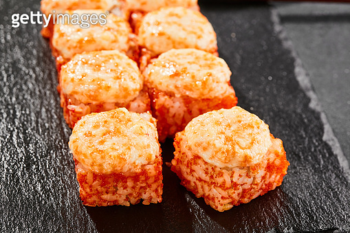 Baked Maki sushi on dark slate. Hot california maki with tobiko. Sushi ...