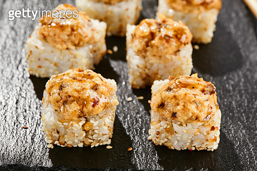 Baked Maki sushi on dark slate. Hot unagi maki with eel. Sushi roll ...