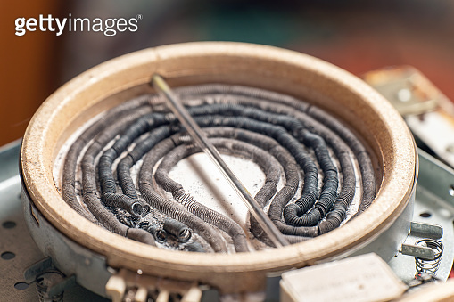 Disassembled electric burner with burned out heating elements, wires ...
