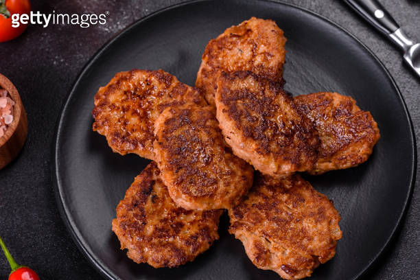 Fish cakes. Fish patties. Fried cutlets of minced fish on a black plate ...