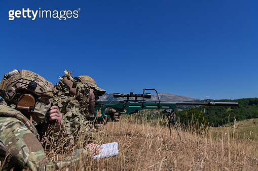 Sniper soldier assisted by an assistant to observe the area to be ...