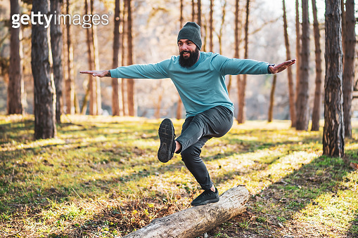 Sporty man walking on tree stump during exercising 이미지 (1385763688 ...