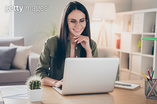 Portrait of charming successful cheerful focused girl working remotely ...