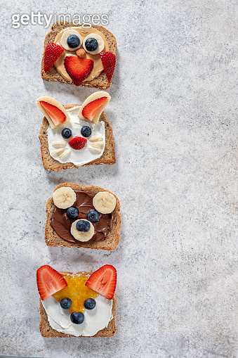 Funny animal faces toasts with spreads, butters, banana, strawberry and ...