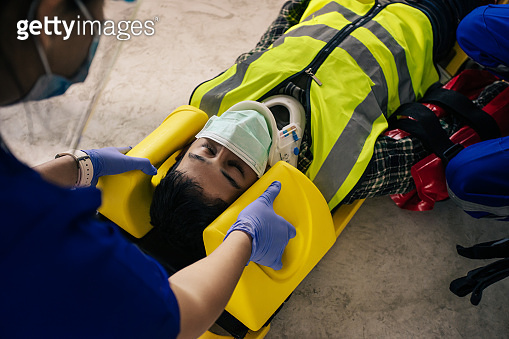 Team EMS Paramedic first aid apply hard collar and spinal board support ...