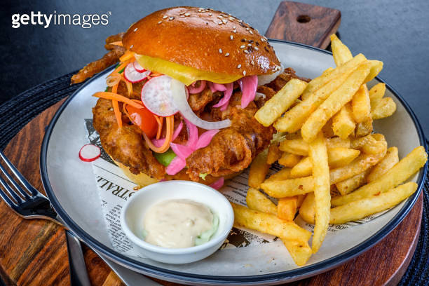 A serve of soft shell crab burger on a round white plate 이미지 ...