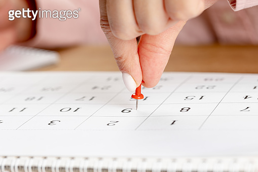 red Hand pin stuck on the day of the month in the calendar, business ...