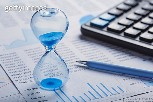 Best time for investment. Hourglass, financial charts and calculator ...