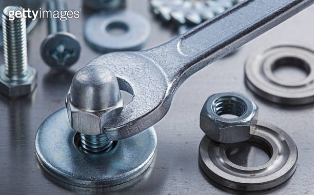 Wrench tightens steel cap nut in steel billet. Spanner, bolt, screw and ...
