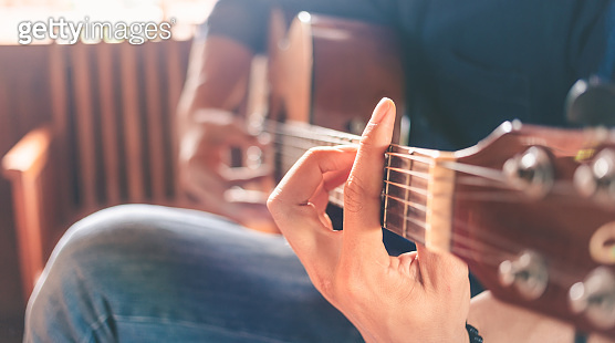Close-up of the hands and fingers of a male musician playing an ...