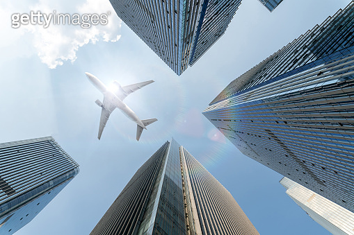 airplane fly over modern office buildings with sunshine, low angle view ...