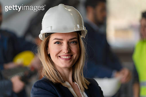 Portrait of female chief engineer in modern industrial factory looking ...