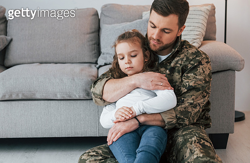 Conception of defending and safety. Soldier in uniform is at home with ...
