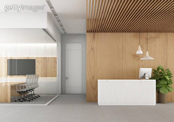 Front view of a white wood reception desk with laptops standing on it ...