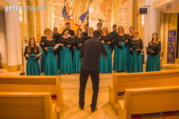 The conductor practices with the choir before the performance. People ...