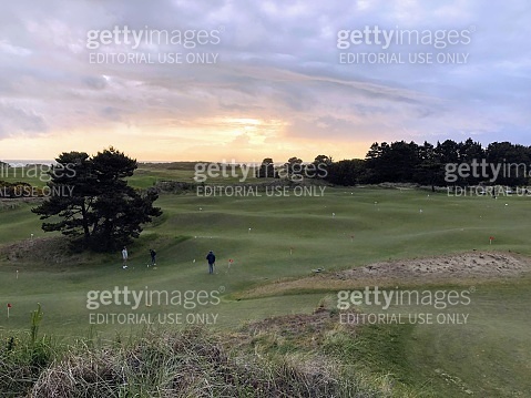 A beautiful view of a large undulated putting green with several ...