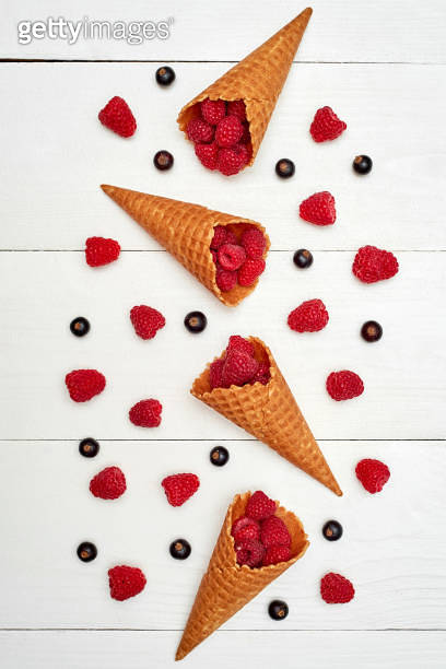 Ripe sweet raspberries and black currant in ice cream waffle cones ...