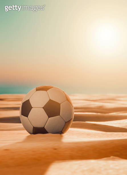 Football lays in the sand while the sun sets (1363114671) - 게티이미지뱅크