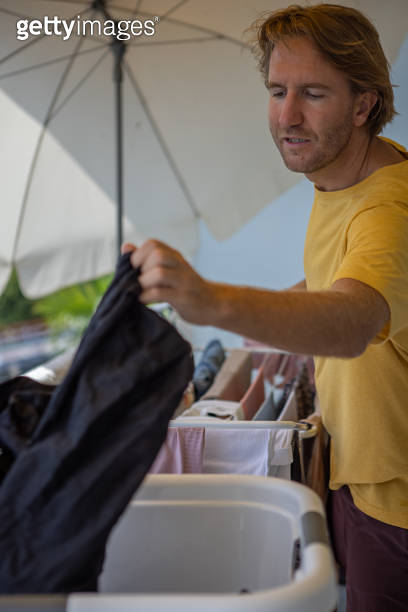 Man hanging laundry to dry (1450325431) - 게티이미지뱅크