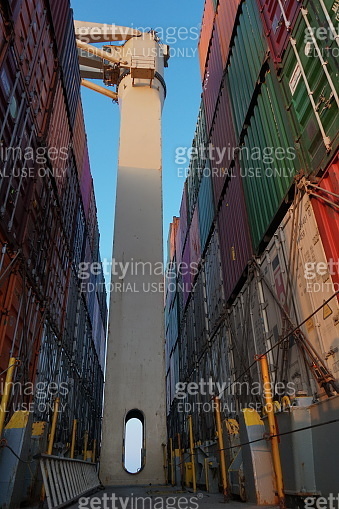 Cream color cargo crane between containers lashed and secured with ...