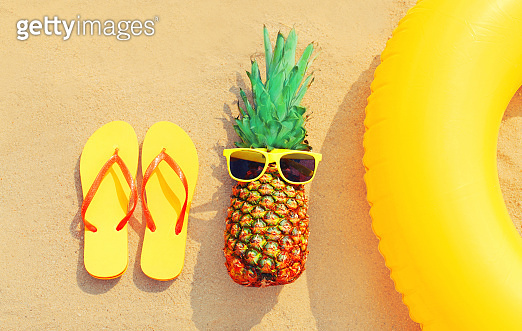 Summer vacation concept - pineapple and inflatable ring with yellow ...