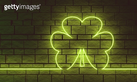 Shamrock shining silhouette. Neon bulb street sign illumination. Brick ...