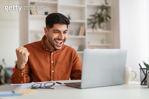Excited man using laptop celebrating success shaking fists screaming ...