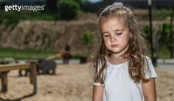 Cute caucasian baby, little girl crying on the playground in the park ...