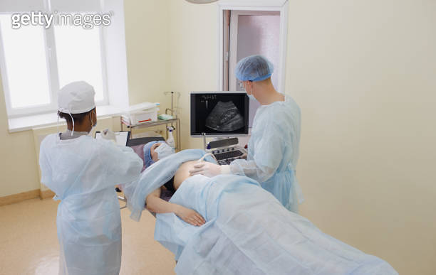 the doctor together with the assistant performs an ultrasound ...
