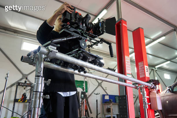 young caucasian cameraman installs a professional movie camera on a ...