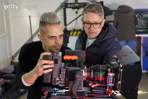 caucasian man director and cameraman stand behind a professional movie ...