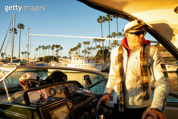 Side View Boat Captain on Yacht in a Tropical Marina with Palm Trees ...