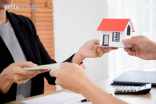 Closeup hand of young real estate agent woman giving house model to ...