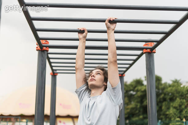 fitness workout on monkey bars outdoors, arm muscles training, climbing ...