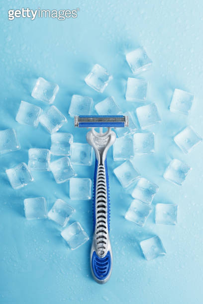 Blue shaving machine with sharp blades on the background of ice cubes ...
