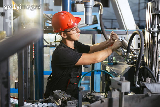 Factory worker working in industrial building indoor. Man fixing ...