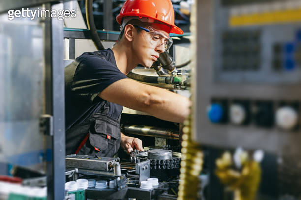 Factory worker working in industrial building indoor. Man fixing ...