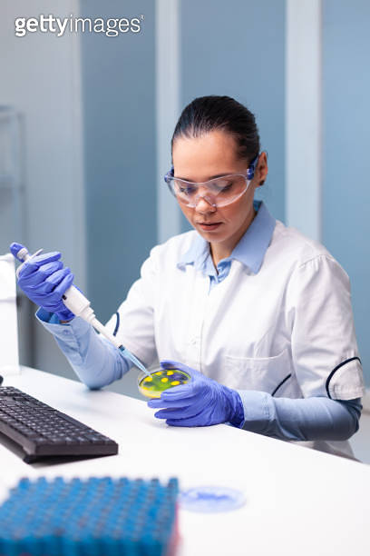 Scientist researcher putting medical solution using micropippete in ...