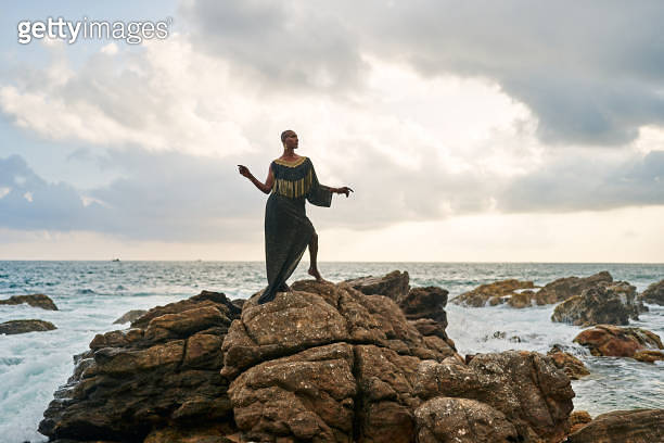 Trans sexual black person poses on scenic ocean beach like a goddess ...