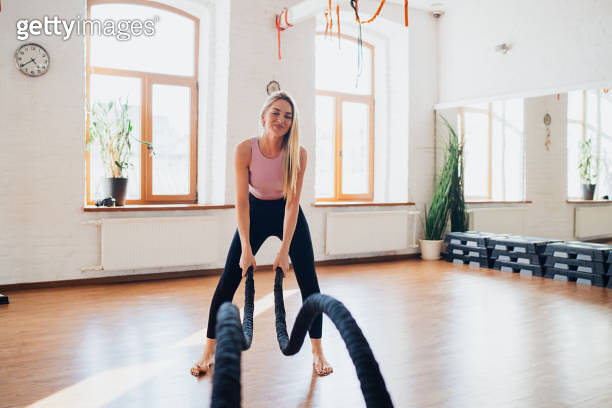 Pretty caucasian young woman in sportswear makes endurance exercise ...